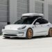 Sporty Touring Tesla Model 3 with Gold Rims and Roof Box