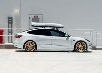 Sporty Touring Tesla Model 3 with Gold Rims and Roof Box - EVMagz