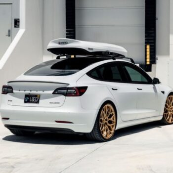 Sporty Touring Tesla Model 3 with Gold Rims and Roof Box